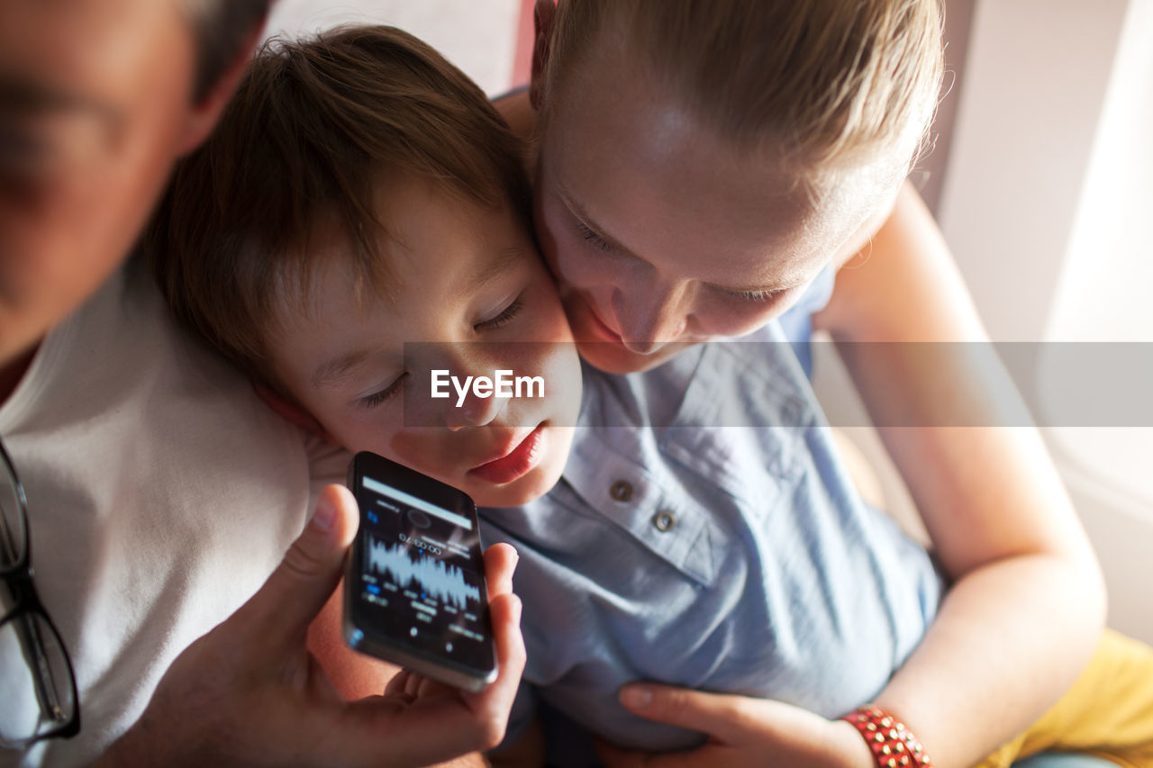 Close-up of father holding mobile phone by | ID: 81157834