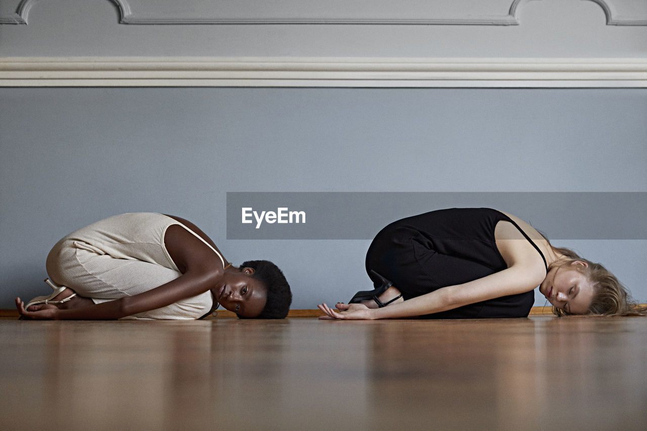 Side view of young women exercising on | ID: 142054455