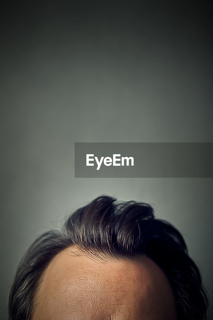 Close-up of man forehead against wall | ID: 120168295