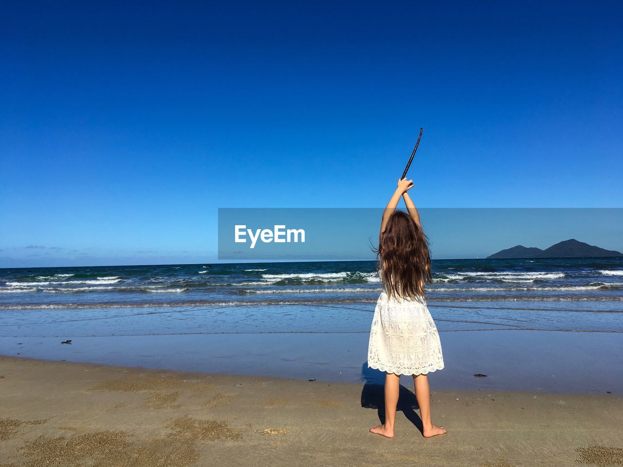 Rear view of girl playing at beach against | ID: 109949235