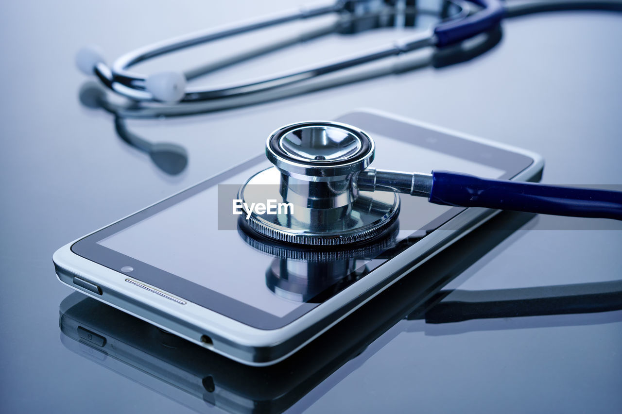 Close-up of stethoscope and mobile phone on | ID: 85104751