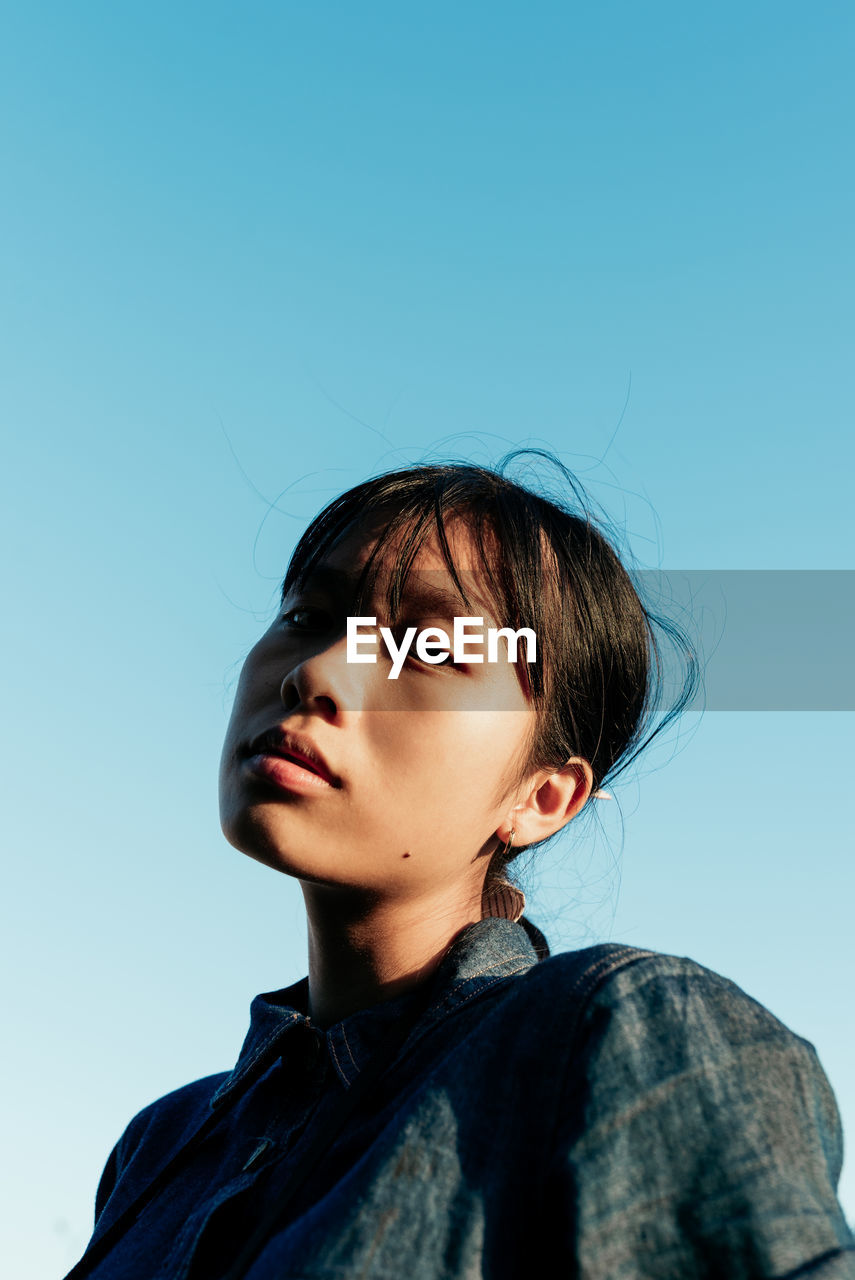 Low angle portrait of young woman against | ID: 136642397