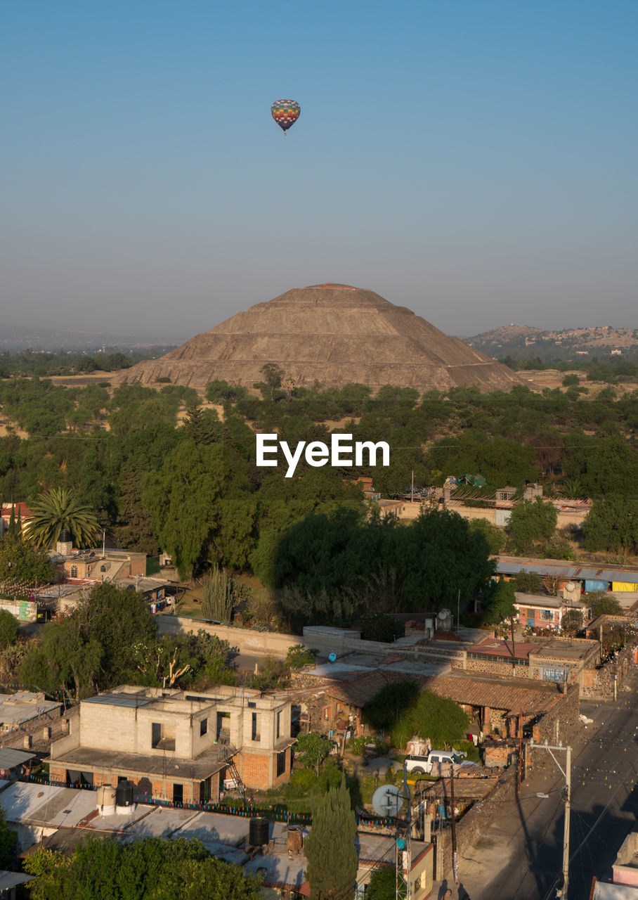 Hot air balloon flying over pyramid against | ID: 122711657