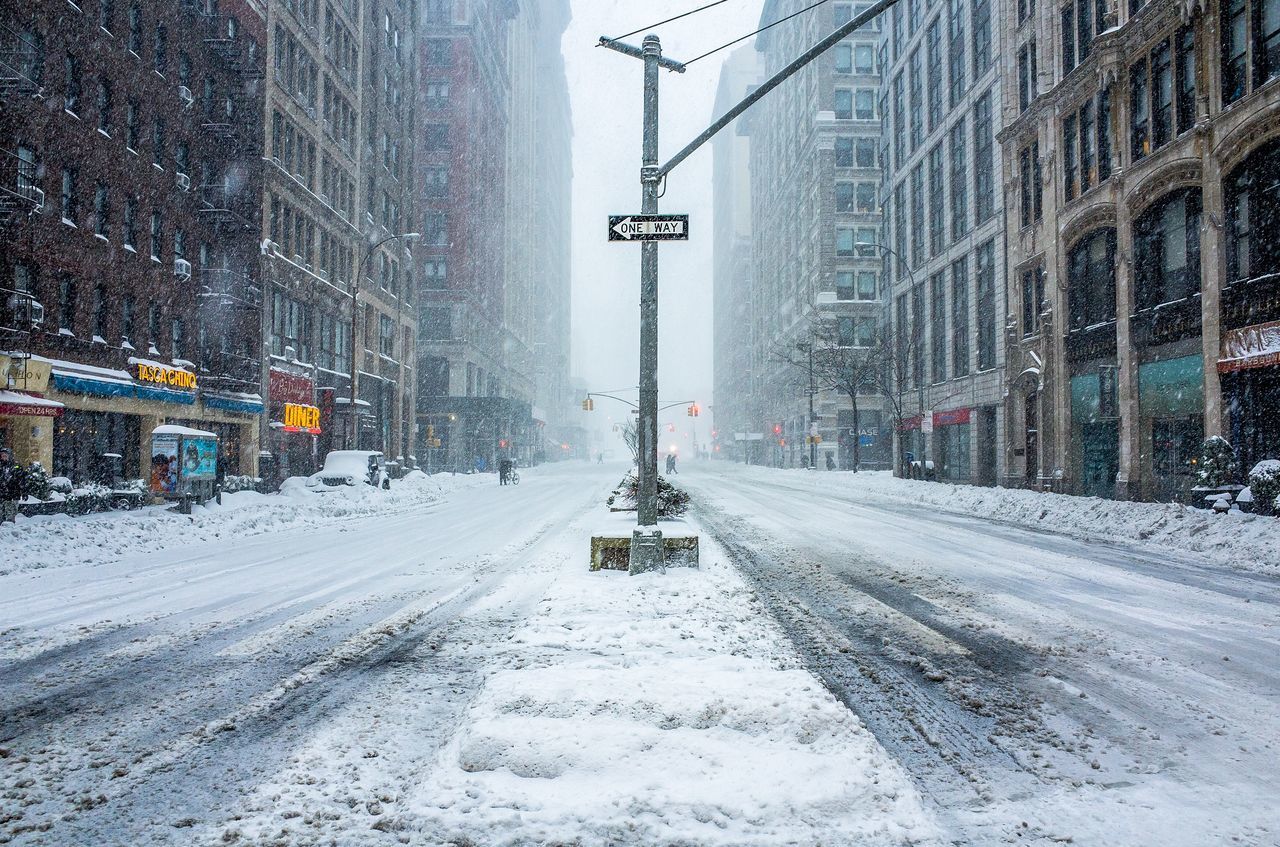 Street covered with snow amidst buildings in | ID: 79985007