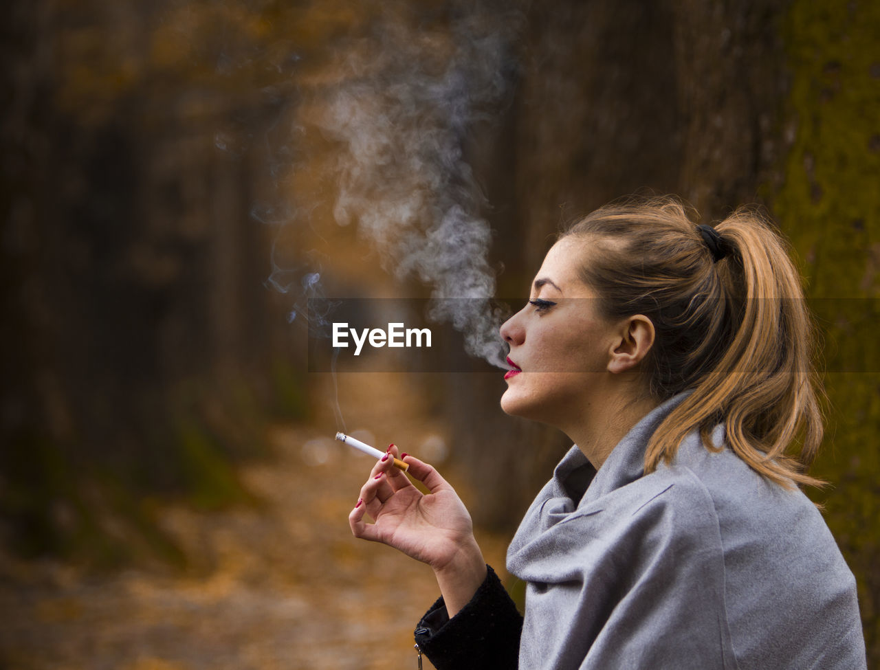 Side view of woman smoking outdoors | ID: 95074314