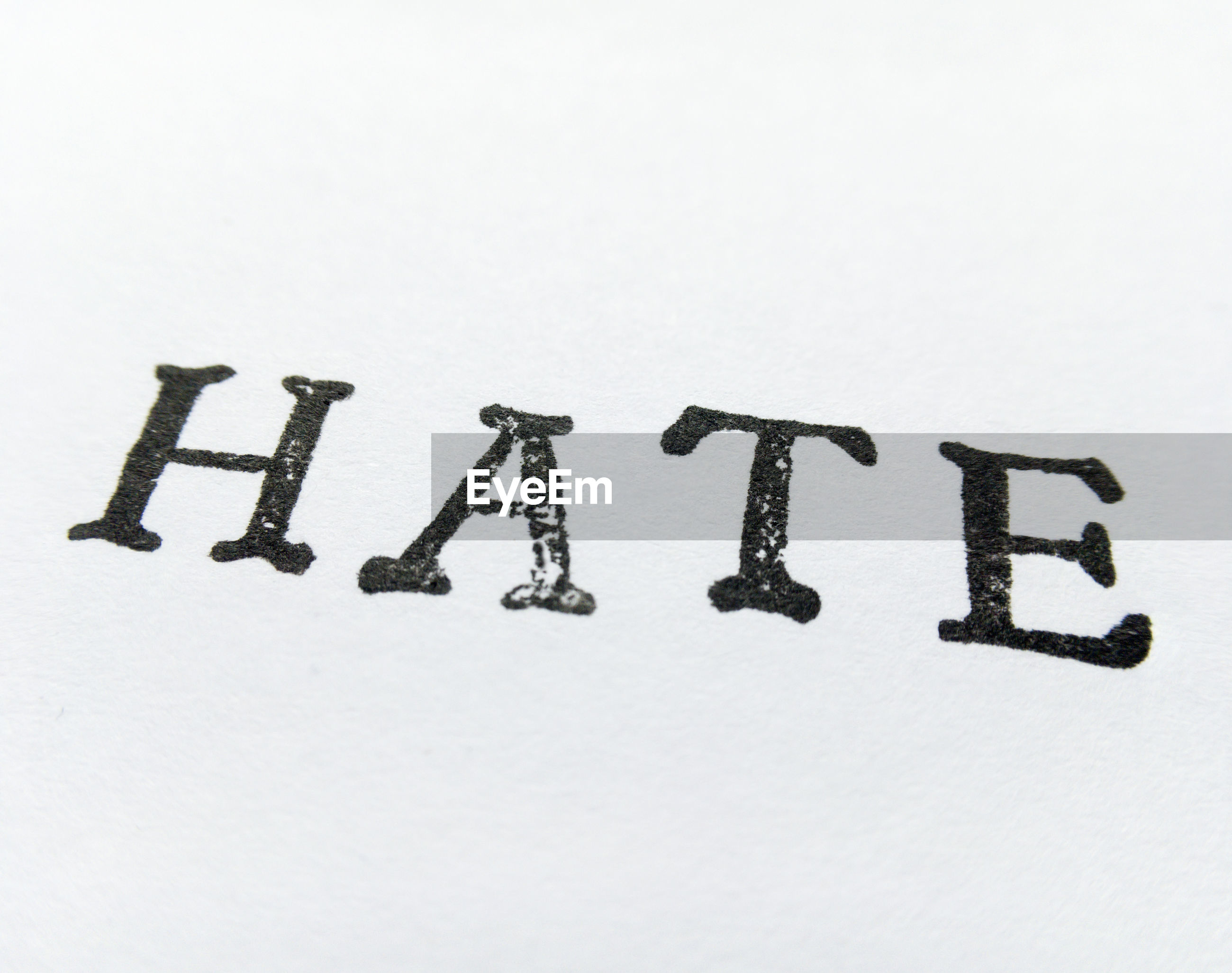 Close-up of hate text on white paper | ID: 107637654