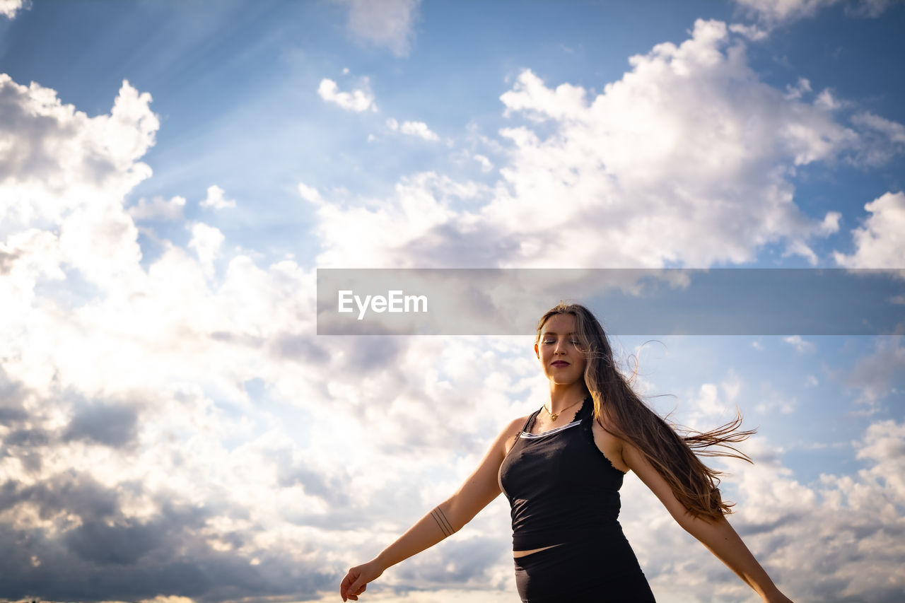 Low angle view of woman standing against sky | ID: 180049327